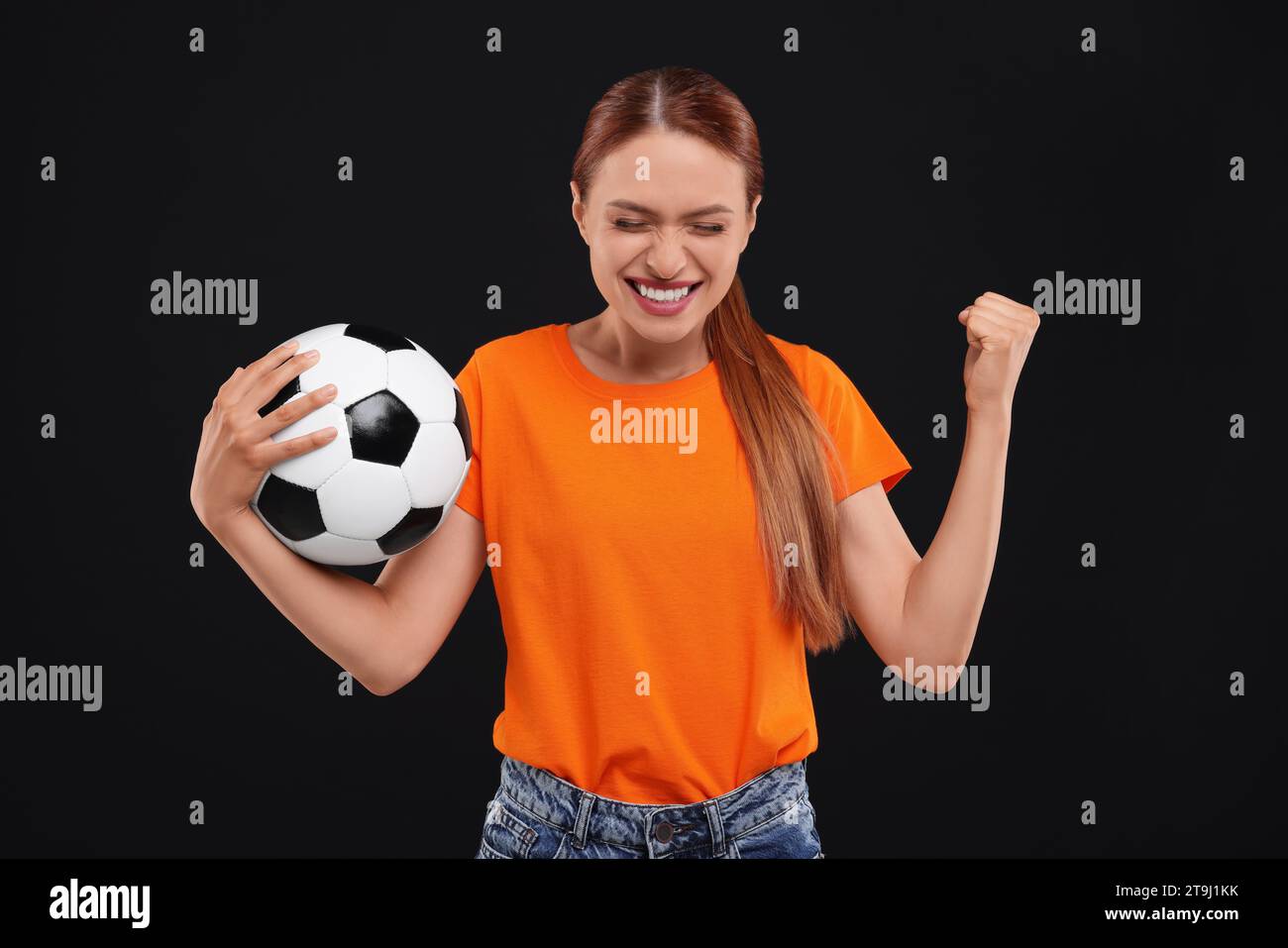 Happy fan with football ball on black background Stock Photo - Alamy