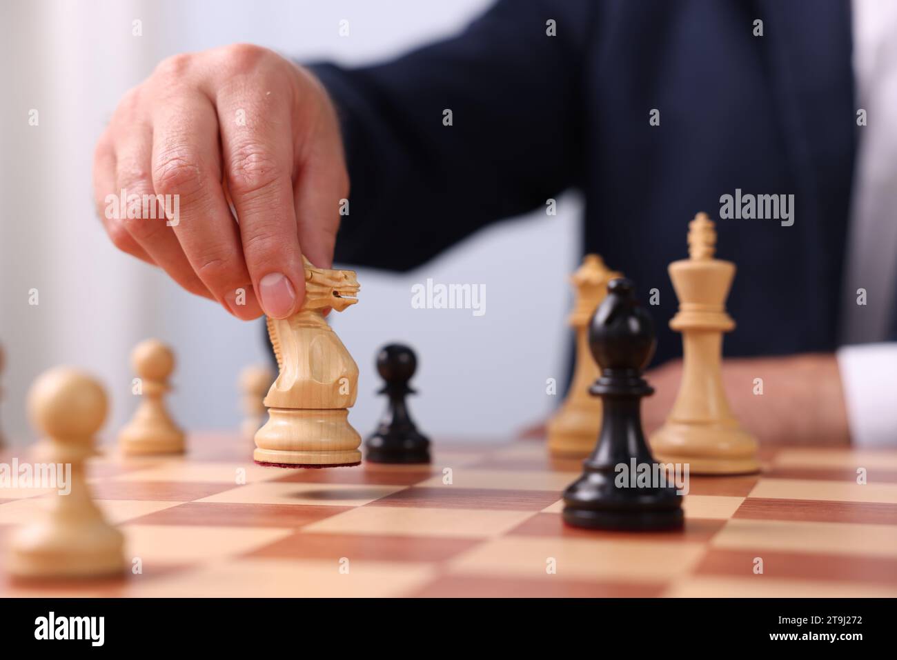 Man with knight playing chess at checkerboard, closeup Stock Photo - Alamy