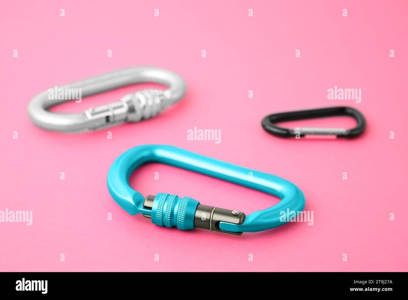 Metal carabiners on bright pink background. Safety equipment Stock ...