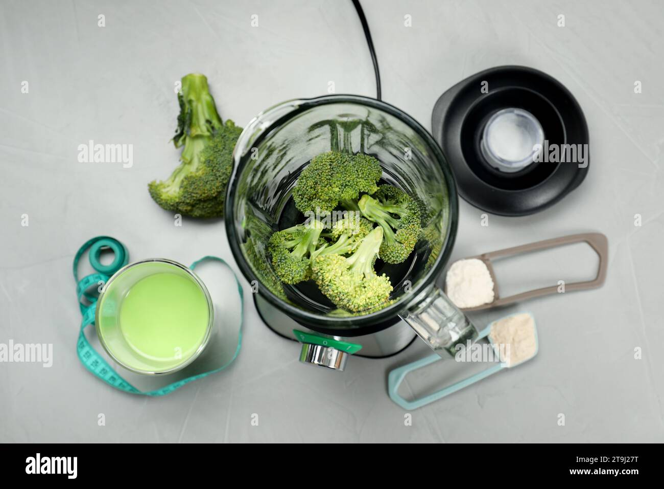 Making shake. Broccoli in blender and scoops with different powders on ...
