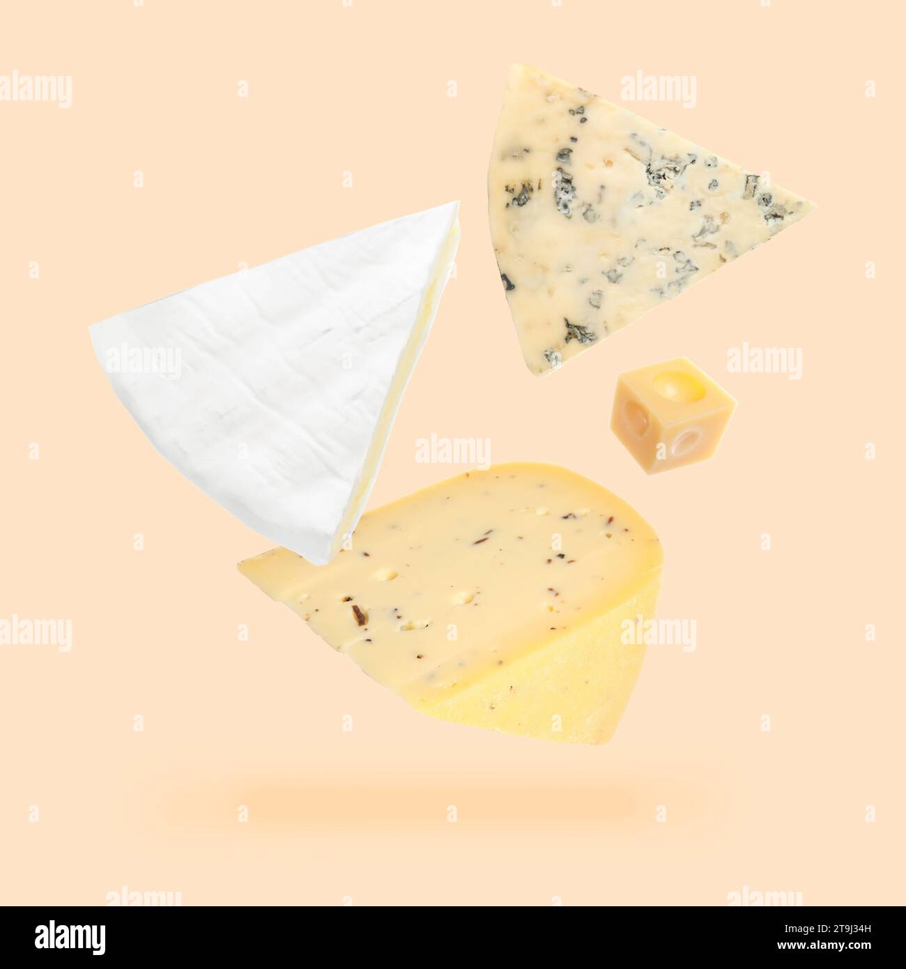 Different kinds of cheese falling on beige background Stock Photo - Alamy