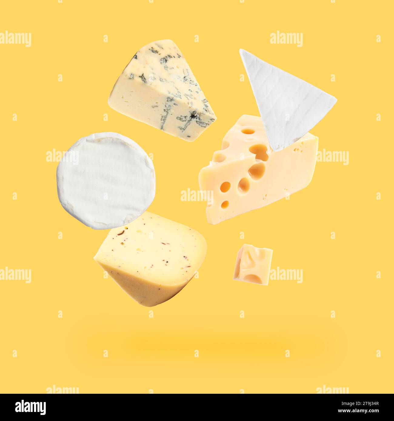 Different kinds of cheese falling on golden background Stock Photo - Alamy