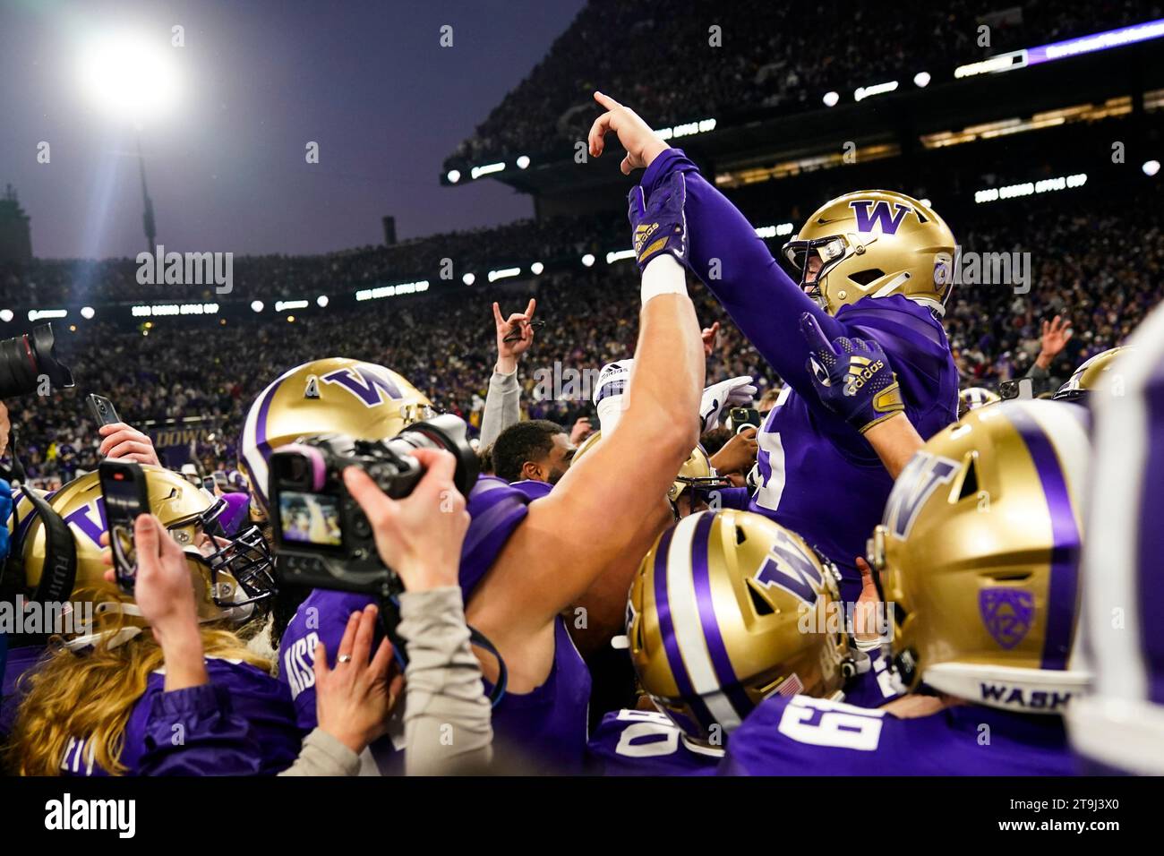 Washington place-kicker Grady Gross lifts his hand up as he is lifted ...