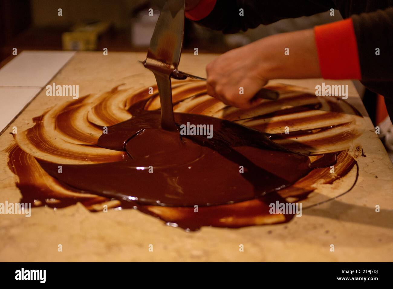 Chocolatier spreading chocolate as a demonstration Stock Photo - Alamy