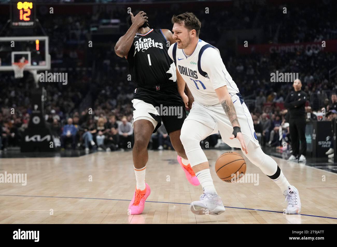 Dallas Mavericks' Luka Doncic, right, drives past Los Angeles Clippers ...