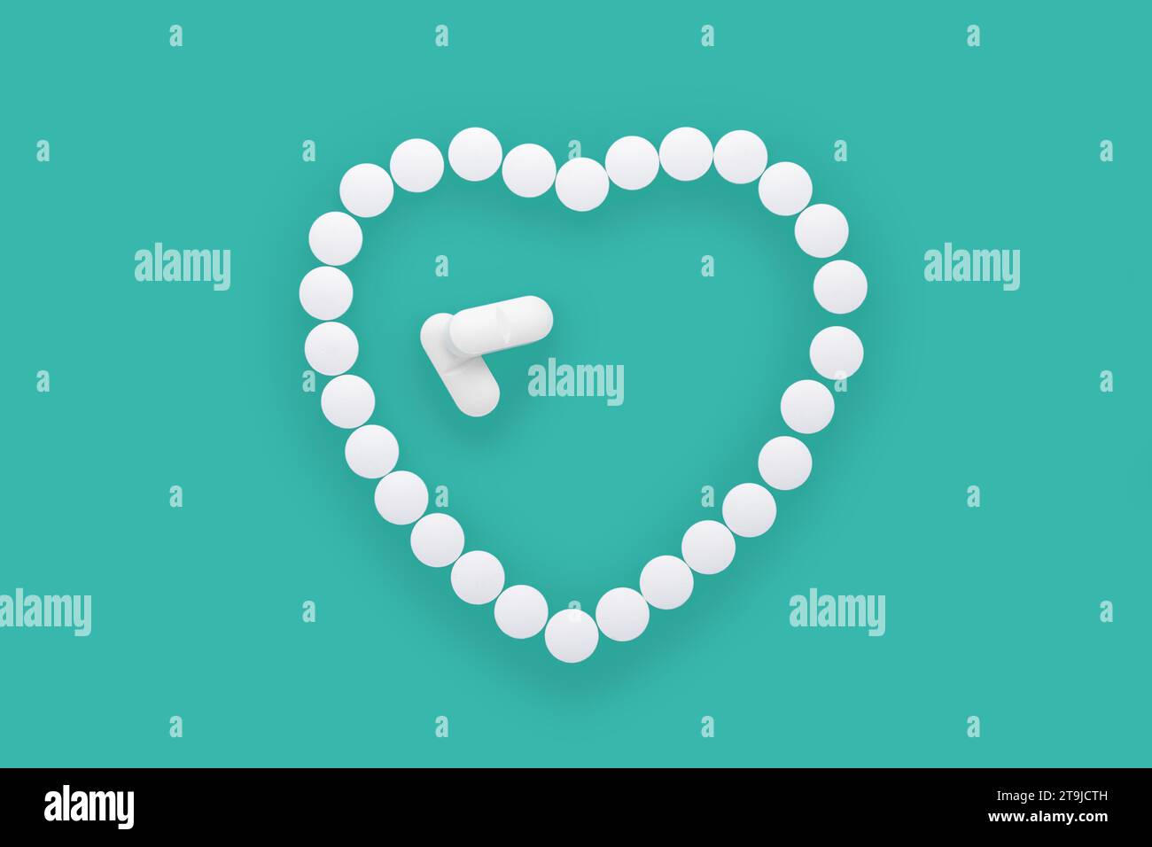 Heart symbol formed white pills or tablets isolated on a blue ...