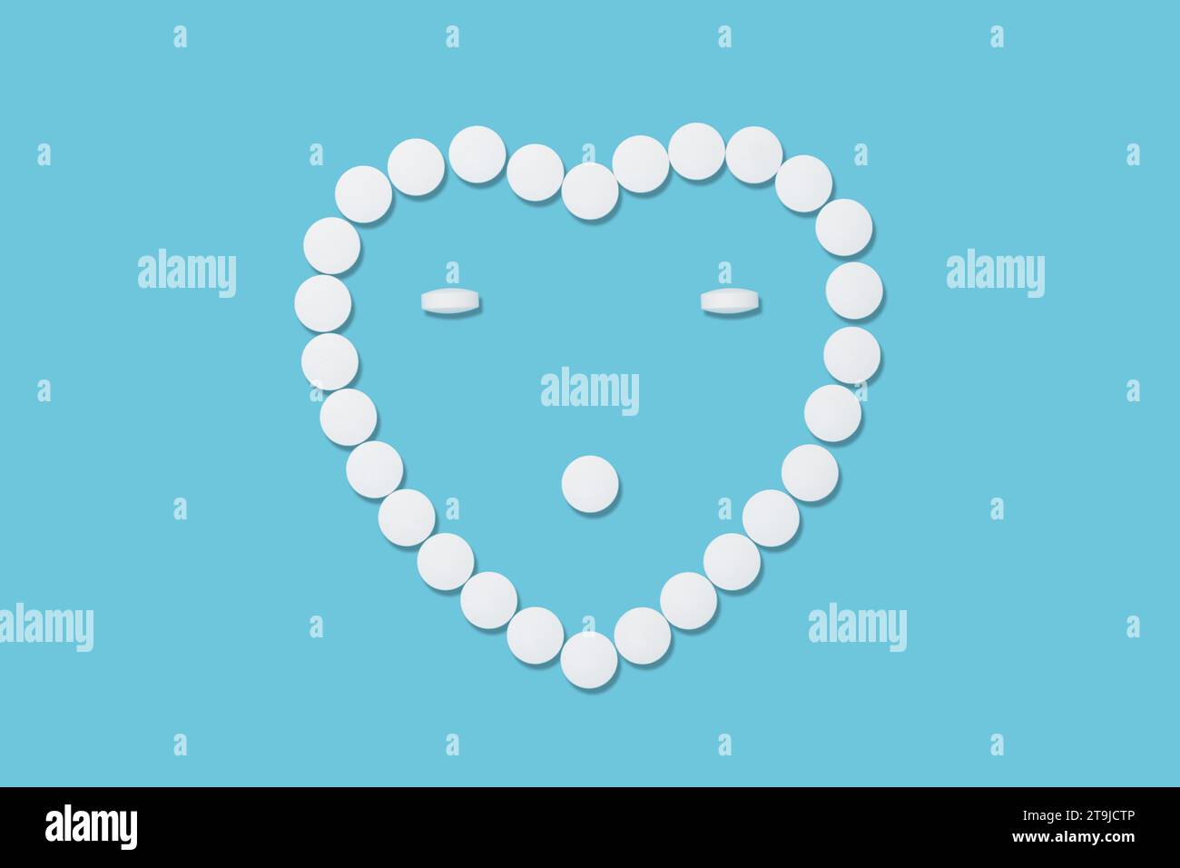 White pills in the shape of a heart on a blue background. Pills for ...