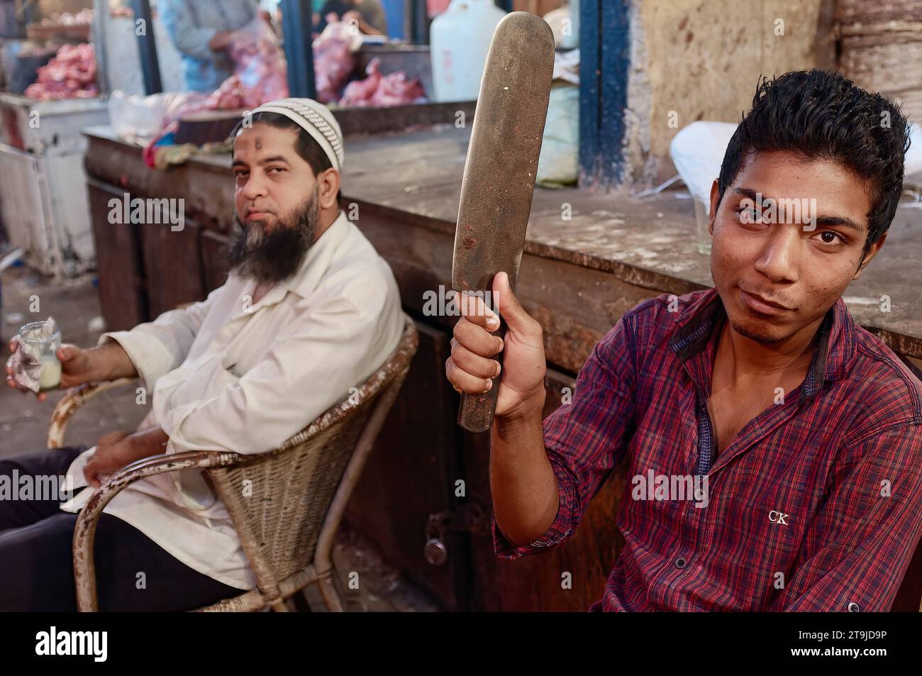 A butcher in a Muslim slaughterhouse greets the photographer with his ...