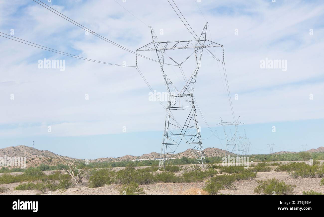 Large tall power lines running through desert landscape with mountains ...