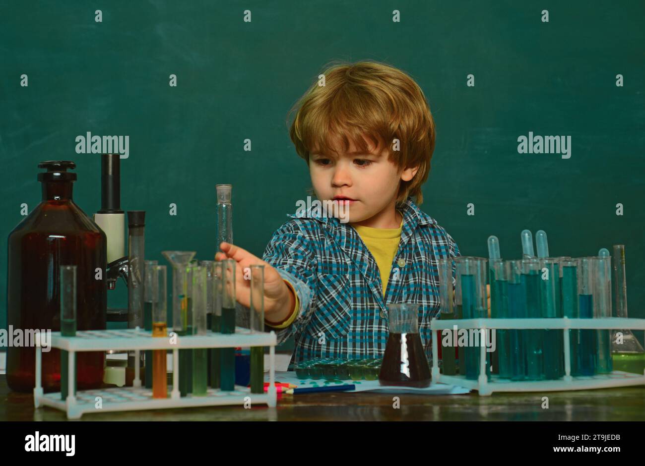 Cheerful smiling little boy having fun against blue wall. Back to ...