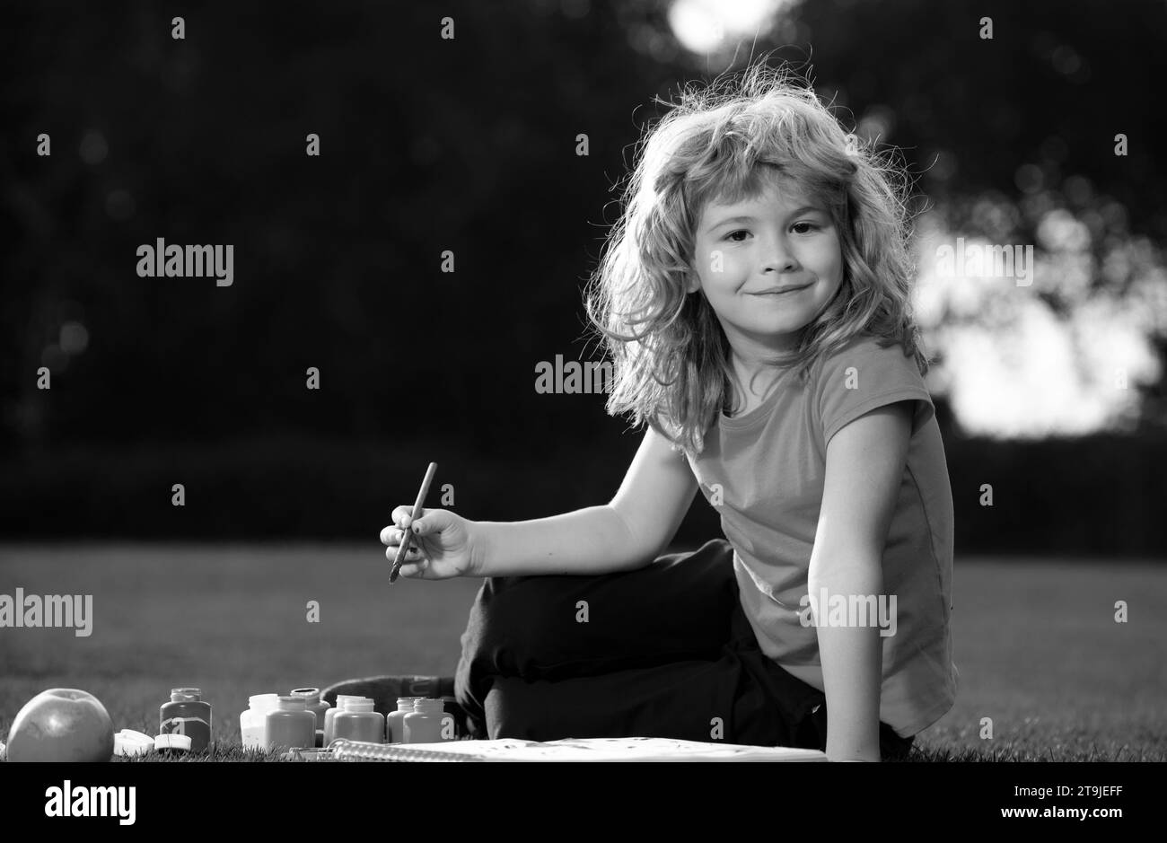 Child boy painting in spring nature. Schooler kids drawing in summer ...