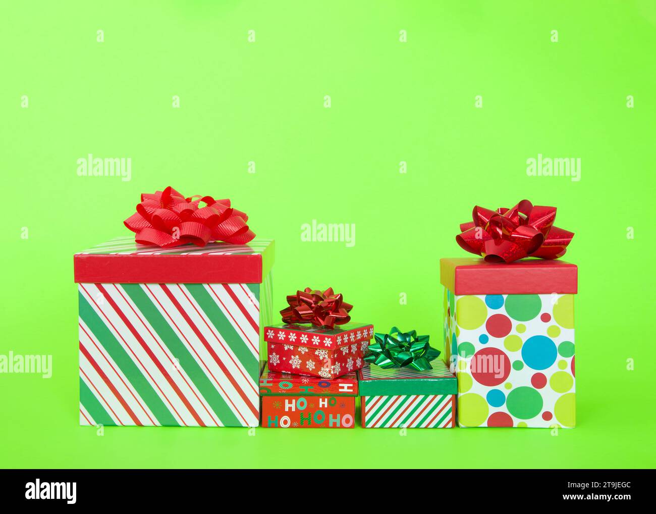 Stack of XMas presents in a row on vibrant green background Stock Photo ...
