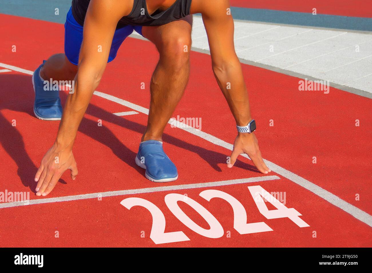 Athlete runner in a pose ready to start on a red treadmill line with ...