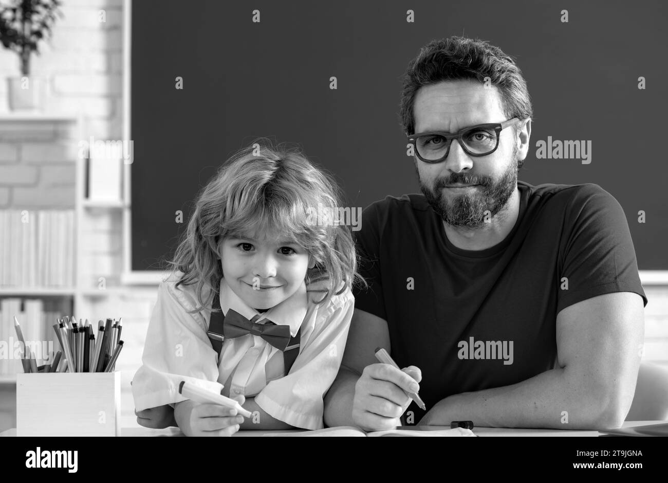 Tutor and child learning at school classroom. Teacher and little ...