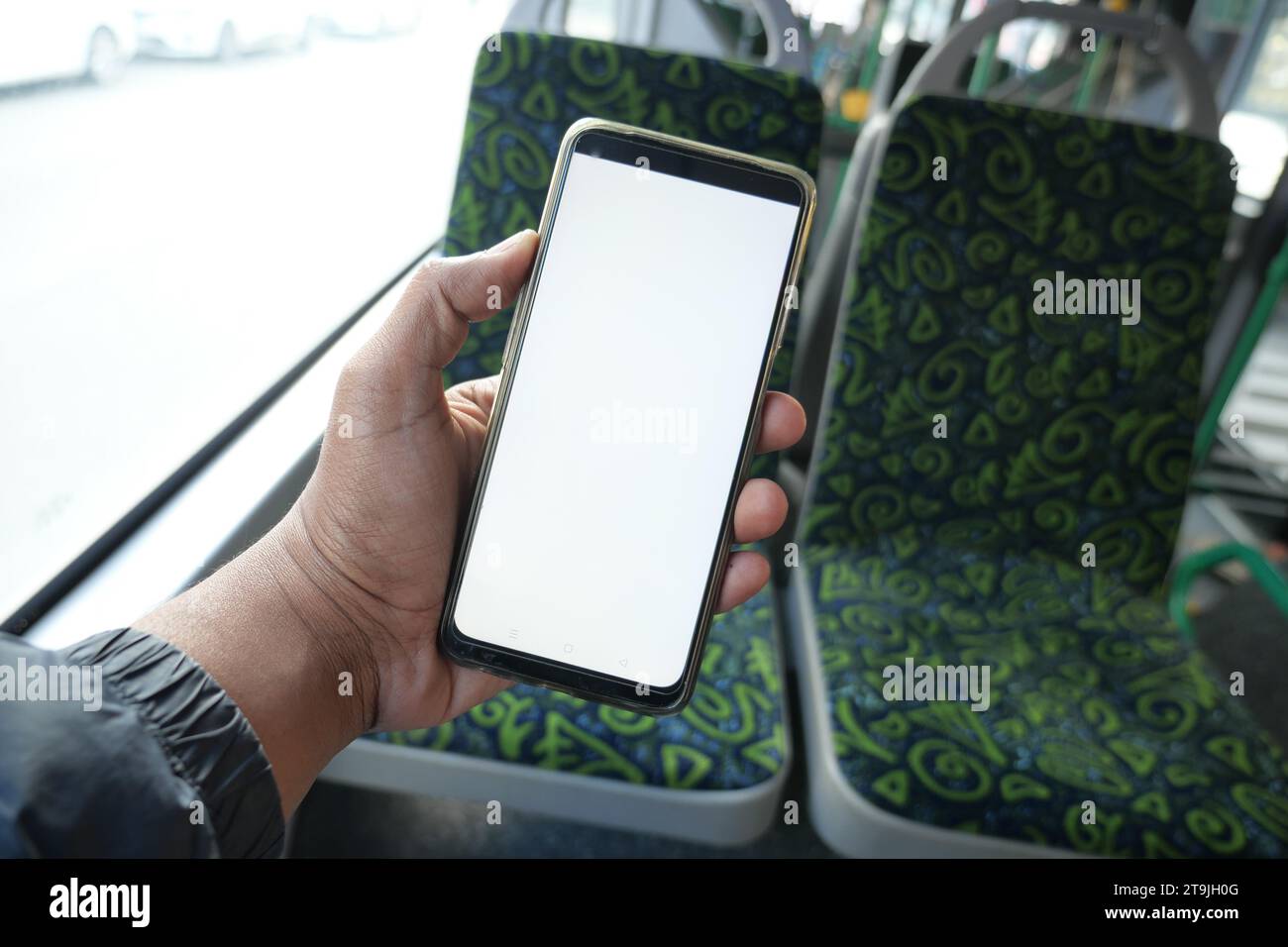 passenger sitting in a bus using his phone Stock Photo - Alamy