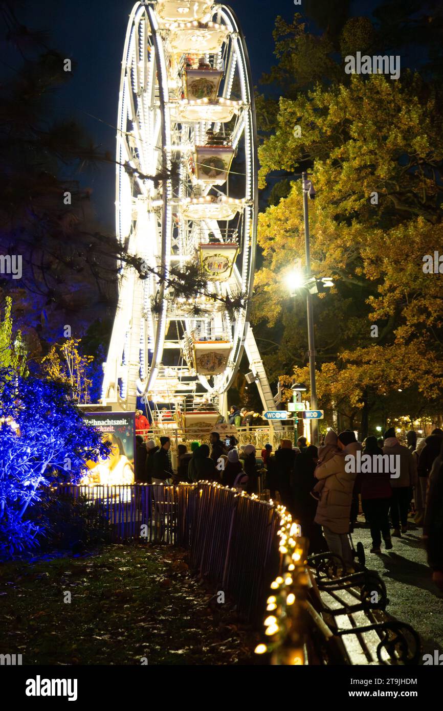 The golden ferris wheel in the middle of the busy Christmas Market ...