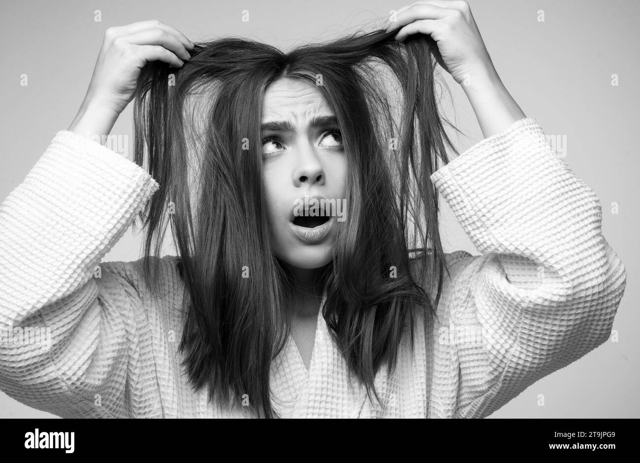 Sad woman looking at damaged hair, the hair loss problem. Studio ...