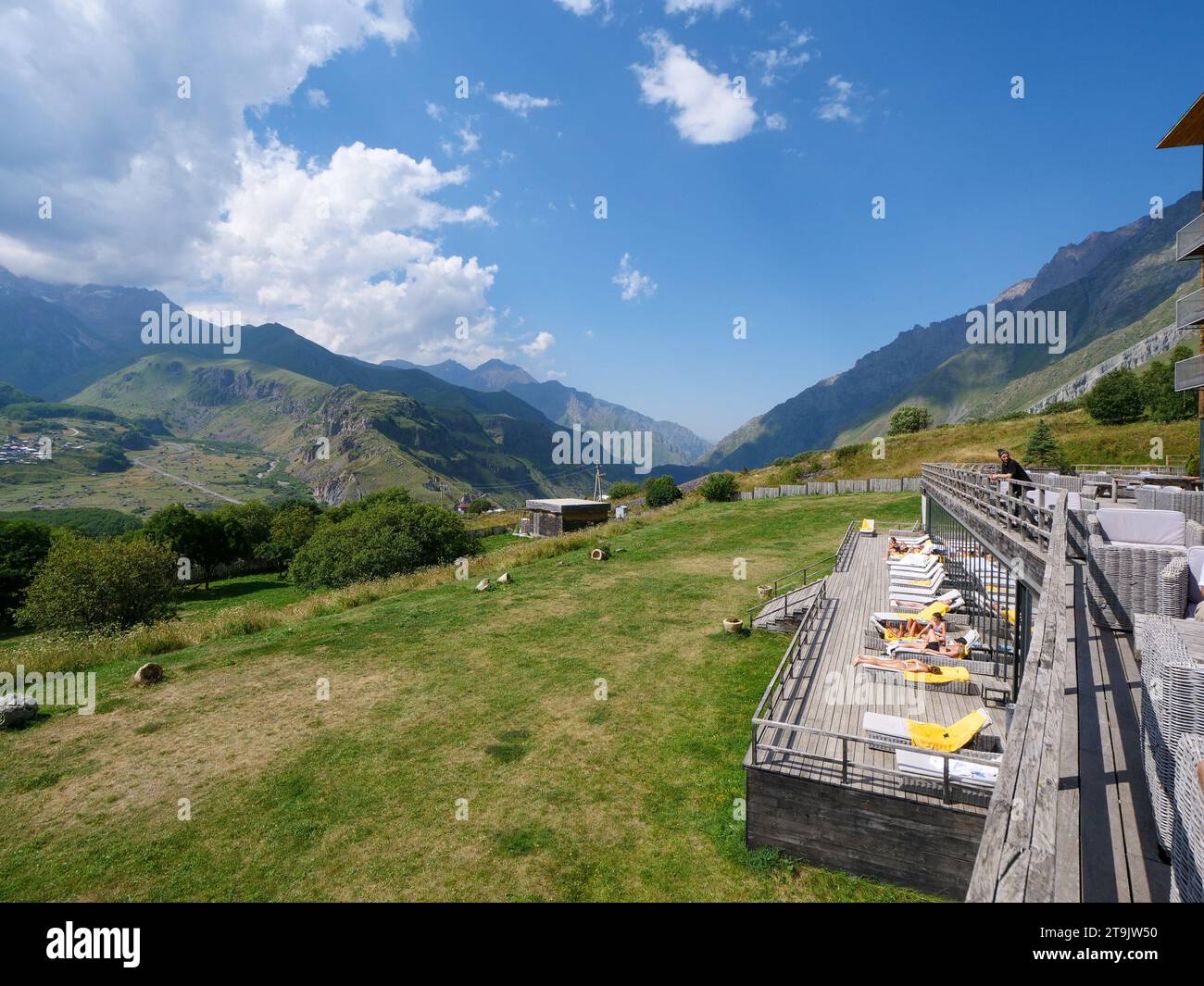 People sunbathing on the terrace of the mountain resort with a ...