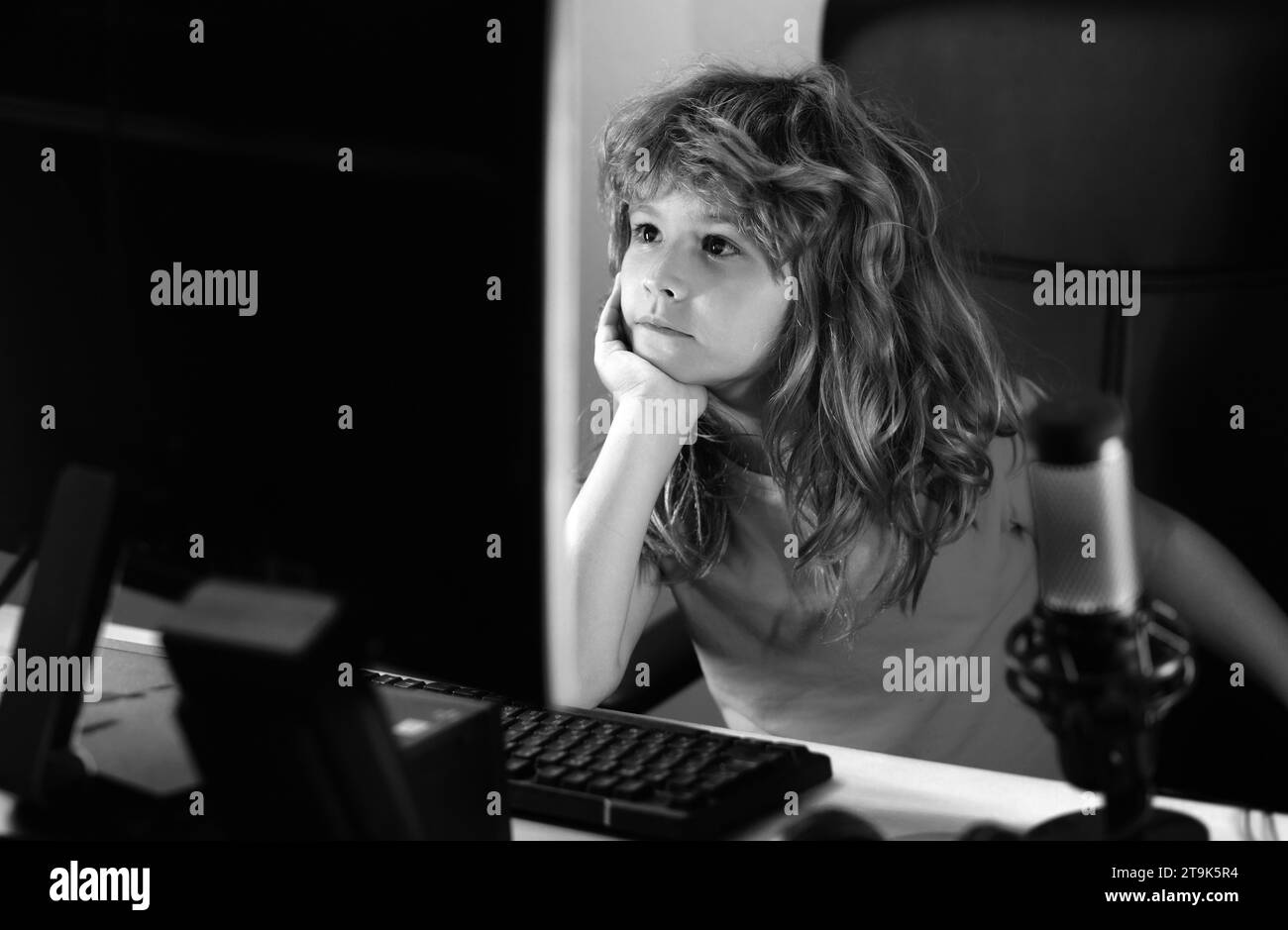 Kid using pc at night. Child with computer in a dark room. Portrait of ...