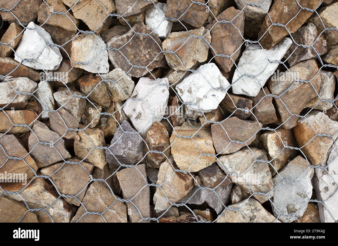 Stones in gabion, wire metal twisted mesh with stones, an element of ...