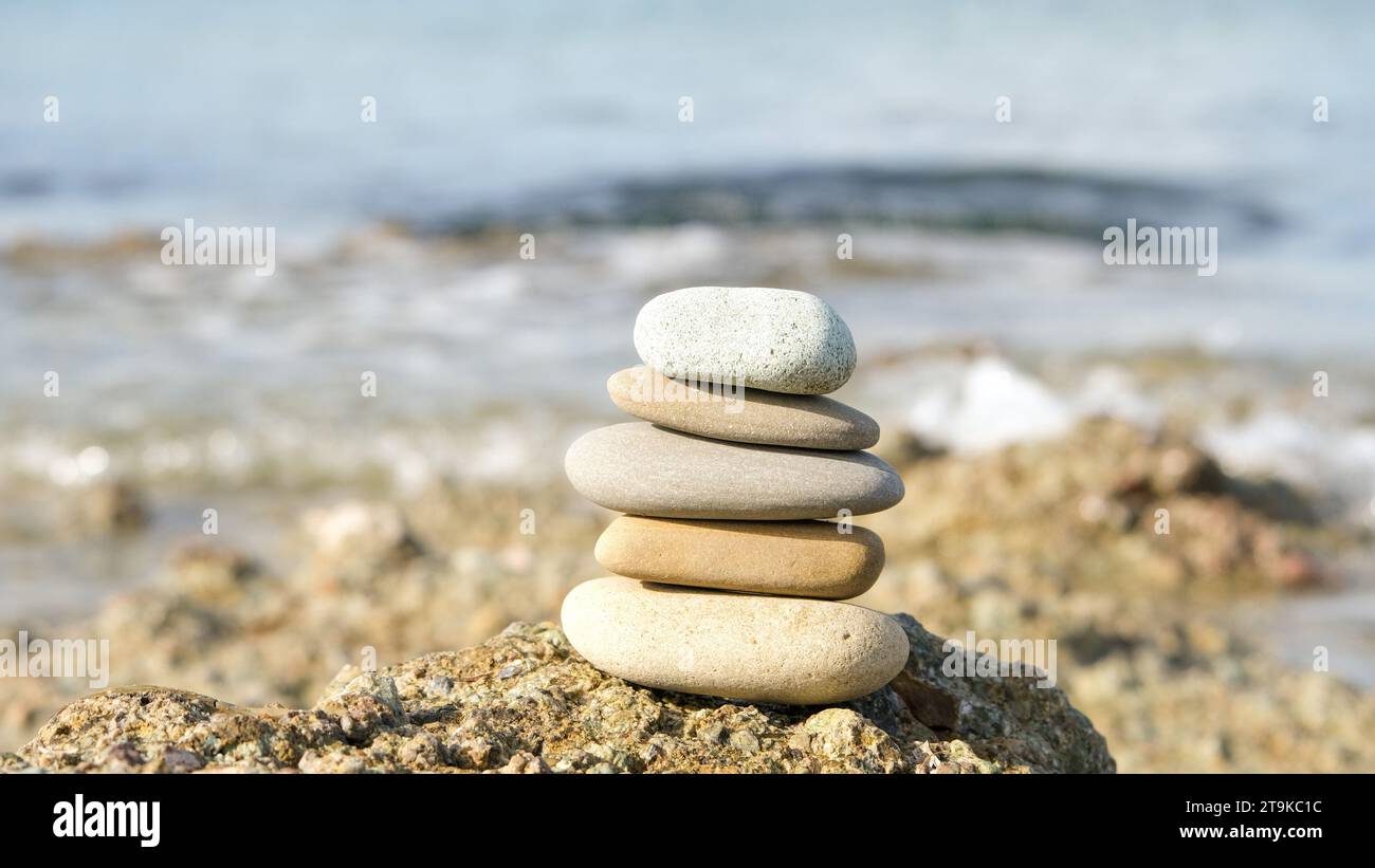 Stone cairn pyramid at seaside. Stack of balanced stones on the beach ...