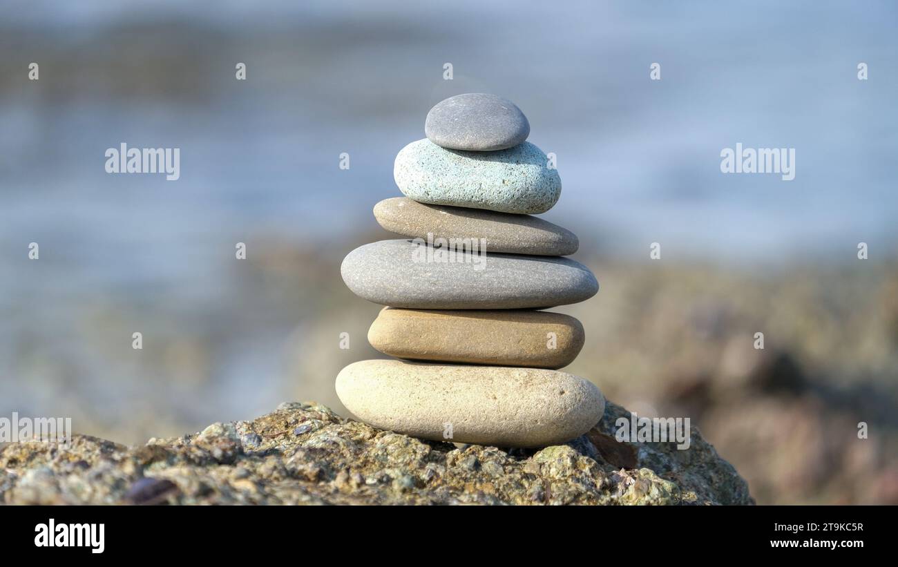 Stone cairn pyramid at seaside. Stack of balanced stones on the beach ...