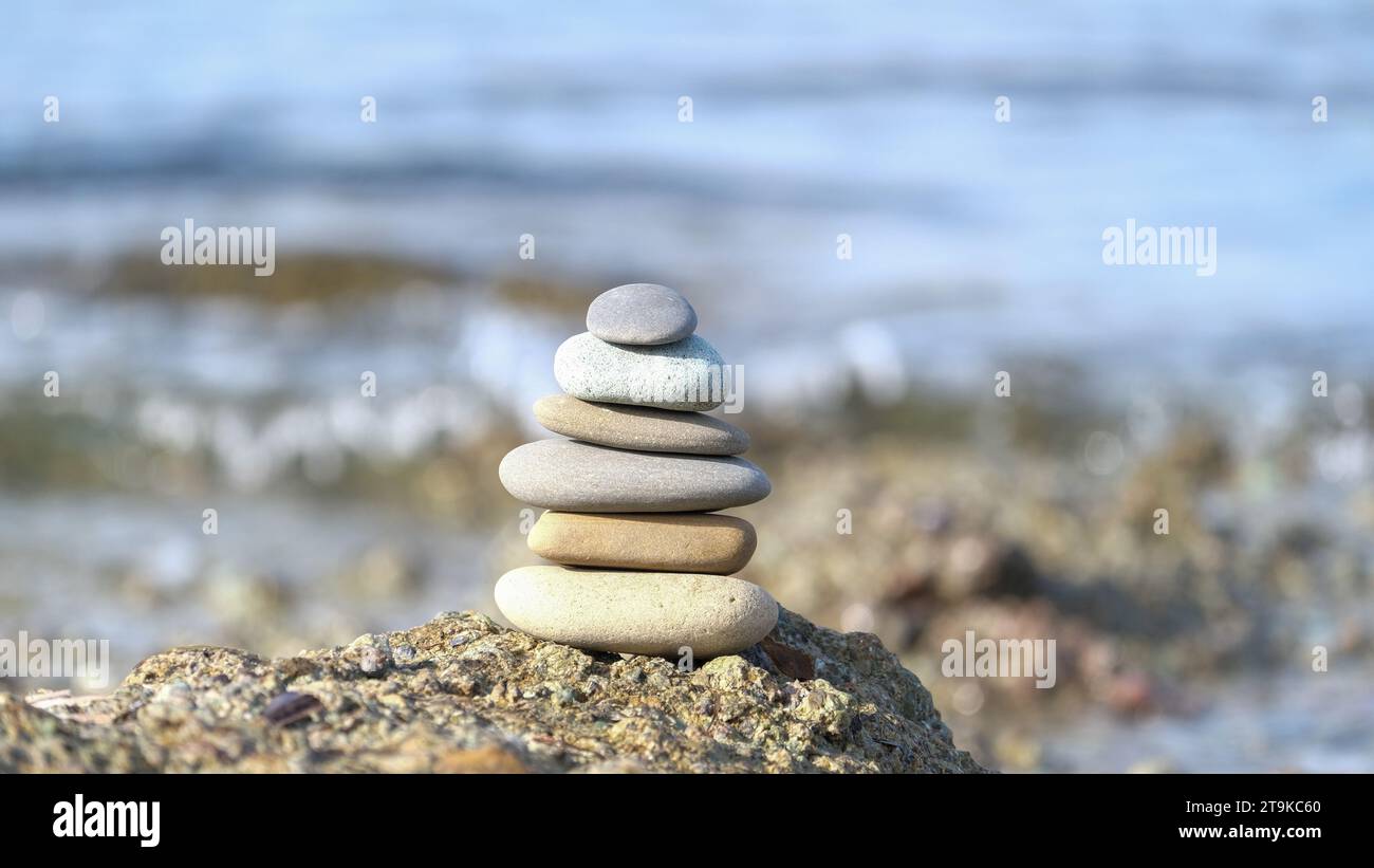 Stone cairn pyramid at seaside. Stack of balanced stones on the beach ...