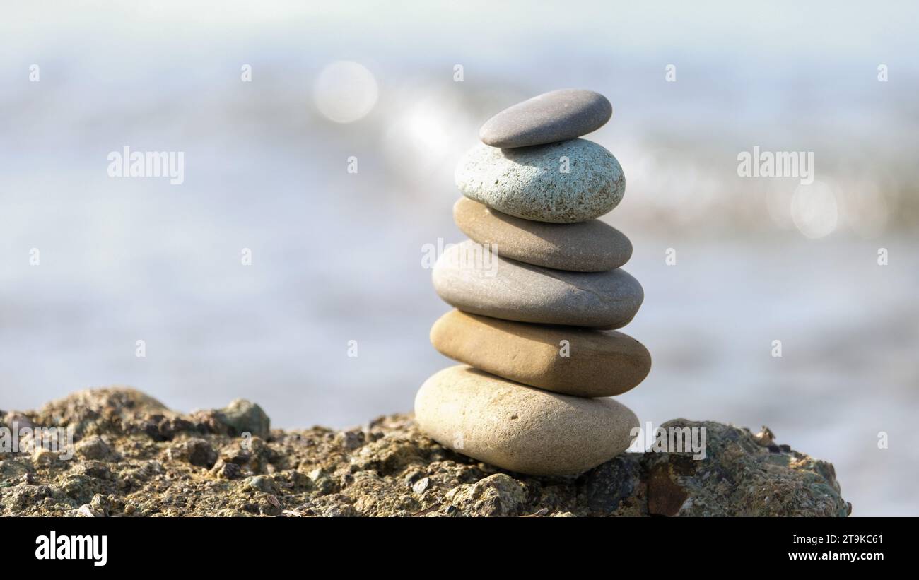Stone cairn pyramid at seaside. Stack of balanced stones on the beach ...