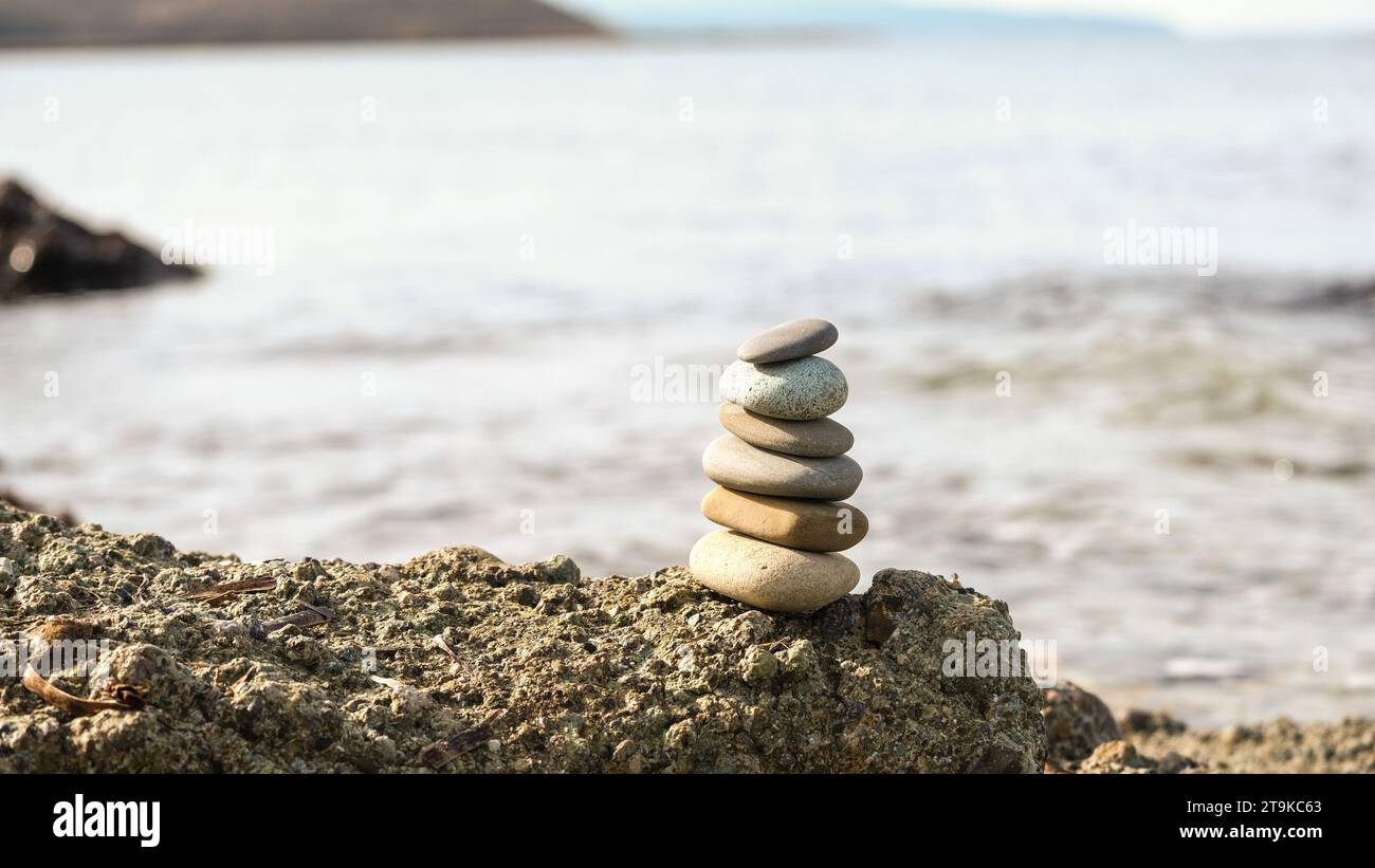 Stone cairn pyramid at seaside. Stack of balanced stones on the beach ...