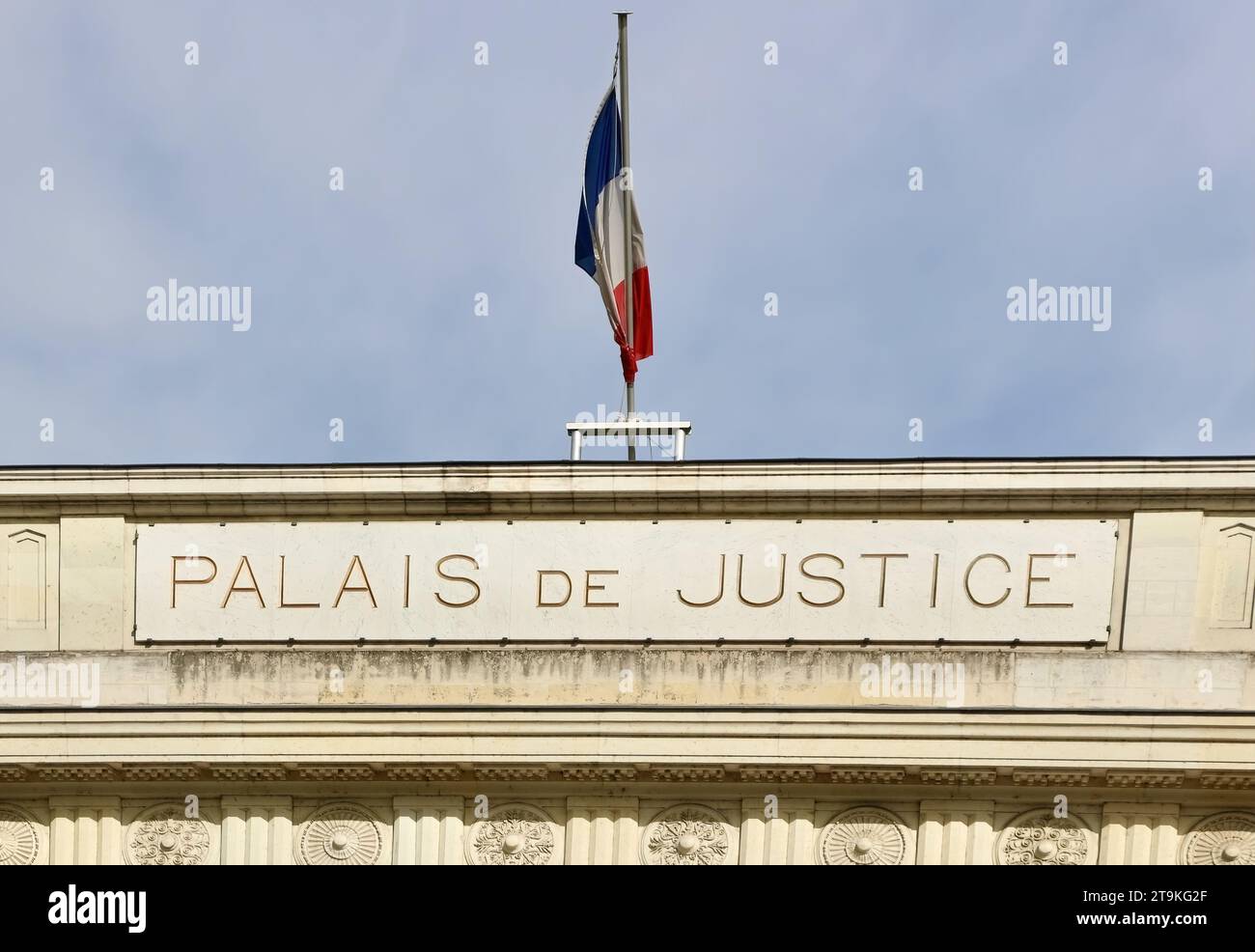 Close up of the stone sign and French flag on the facade of the Palace ...