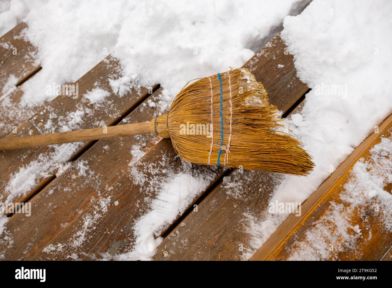 cleaning hardwood steps from snow with old broom, winter scene, no ...