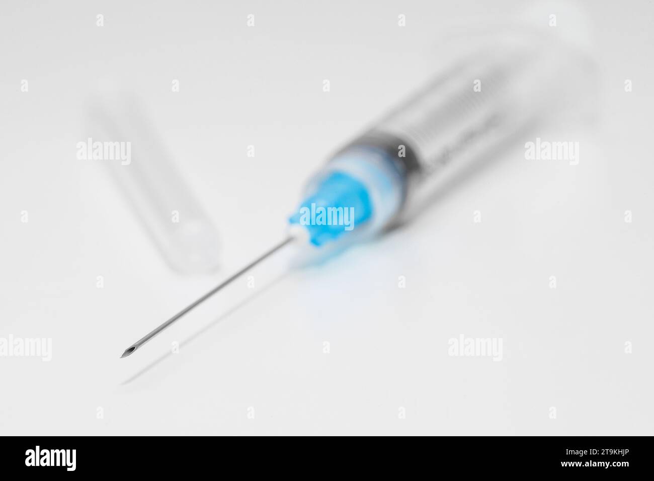 Medical syringe, needle tip close-up with lid removed, bokeh effect ...