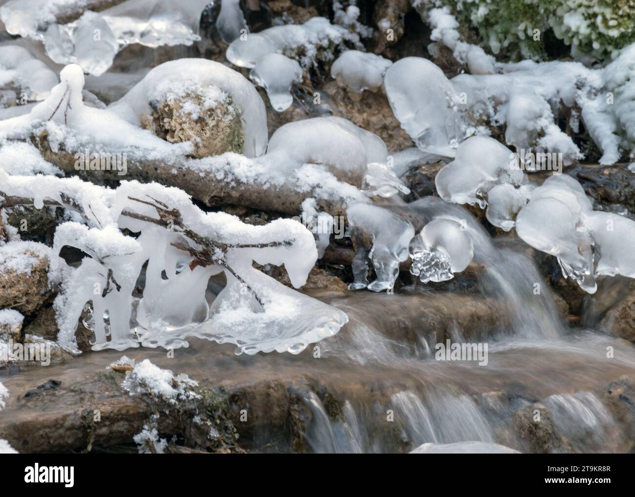 frozen fast flowing spring water, icy rocks and water stream, frosty ...