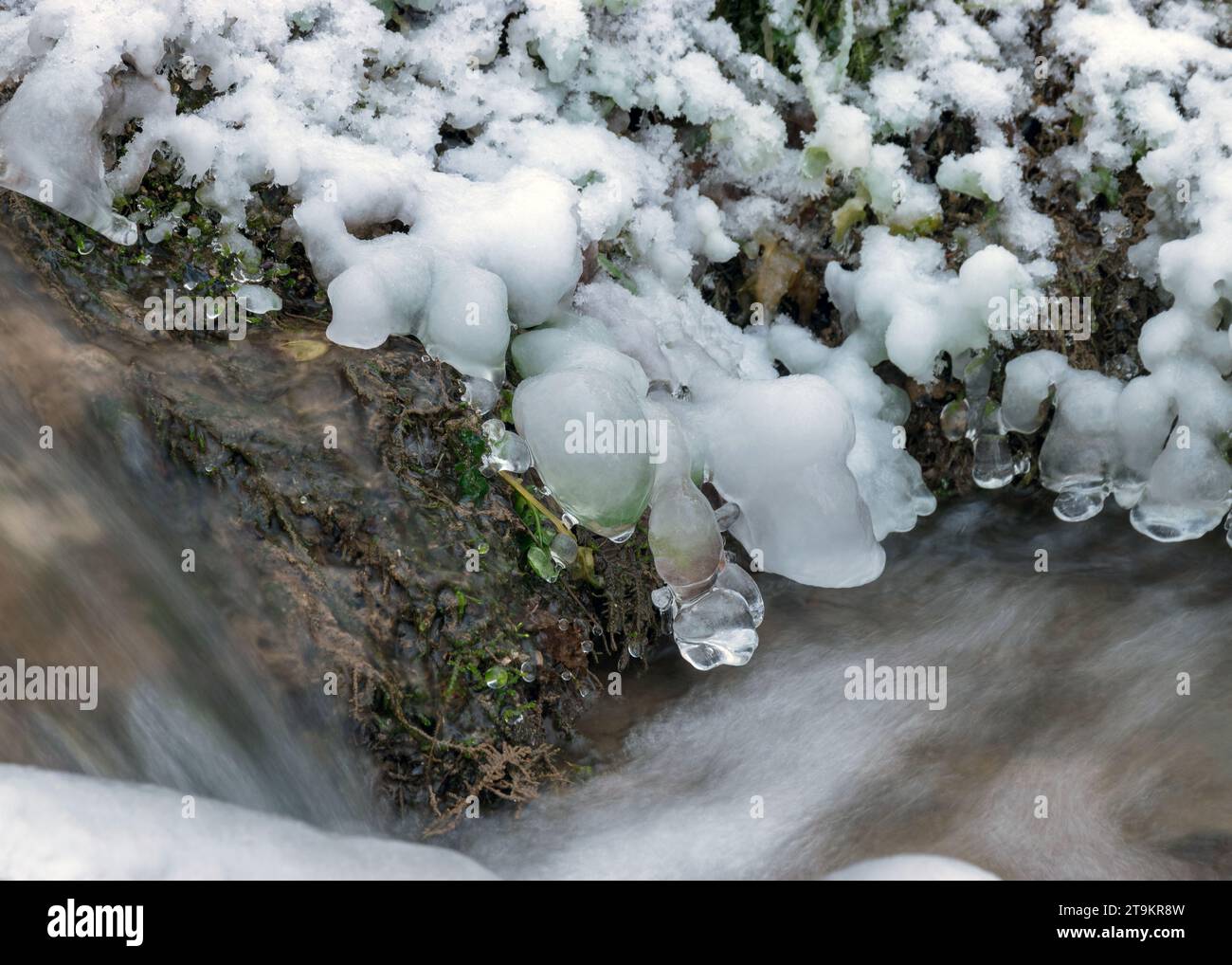 frozen fast flowing spring water, icy rocks and water stream, frosty ...