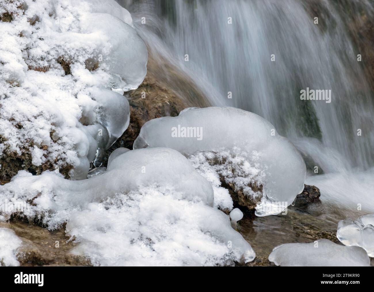 frozen fast flowing spring water, icy rocks and water stream, frosty ...