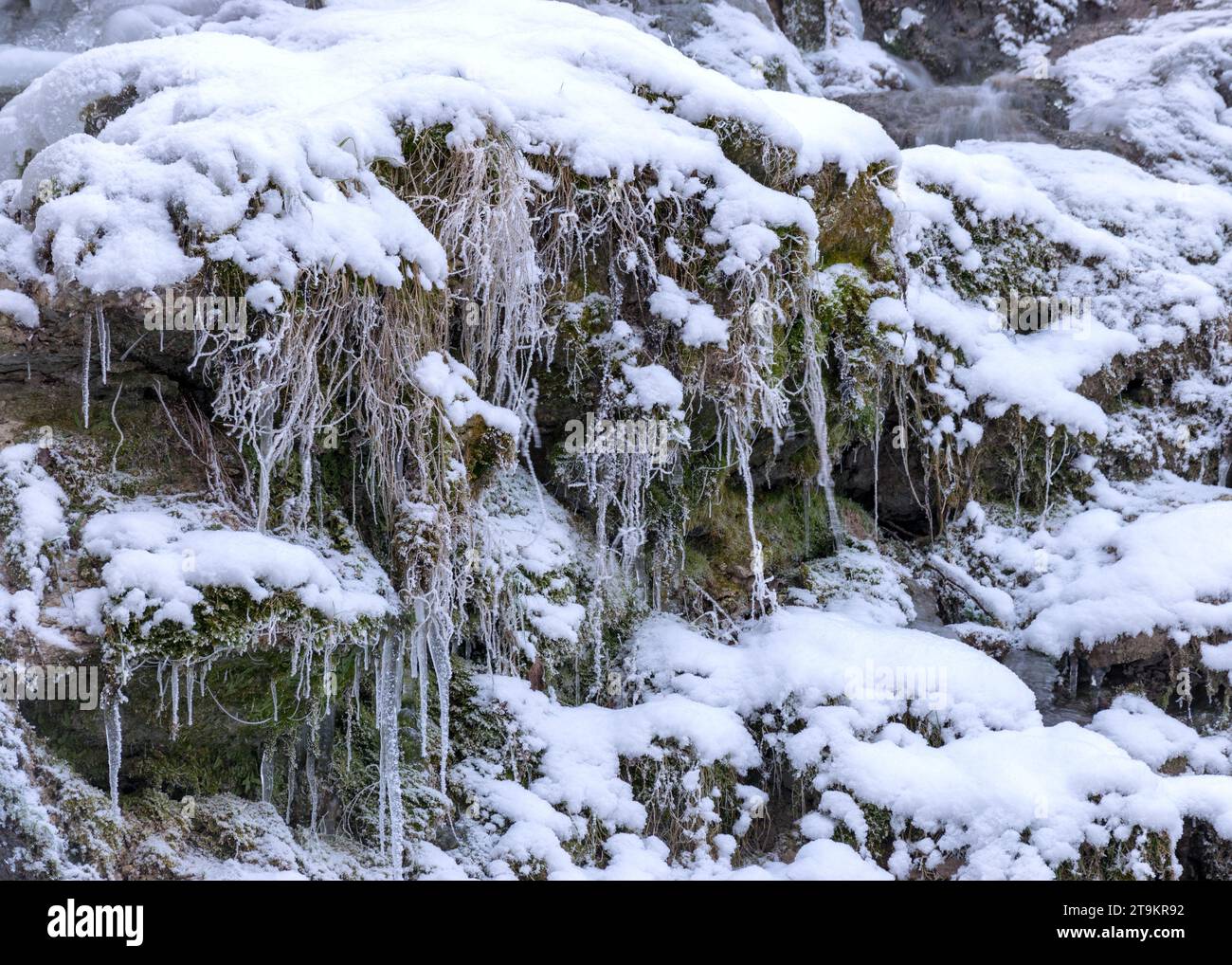 frozen fast flowing spring water, icy rocks and water stream, frosty ...