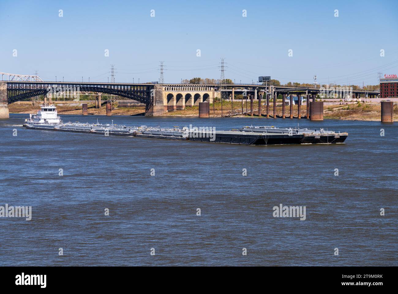 Powerful pusher tugboat with barges of petroleum products under Eads ...