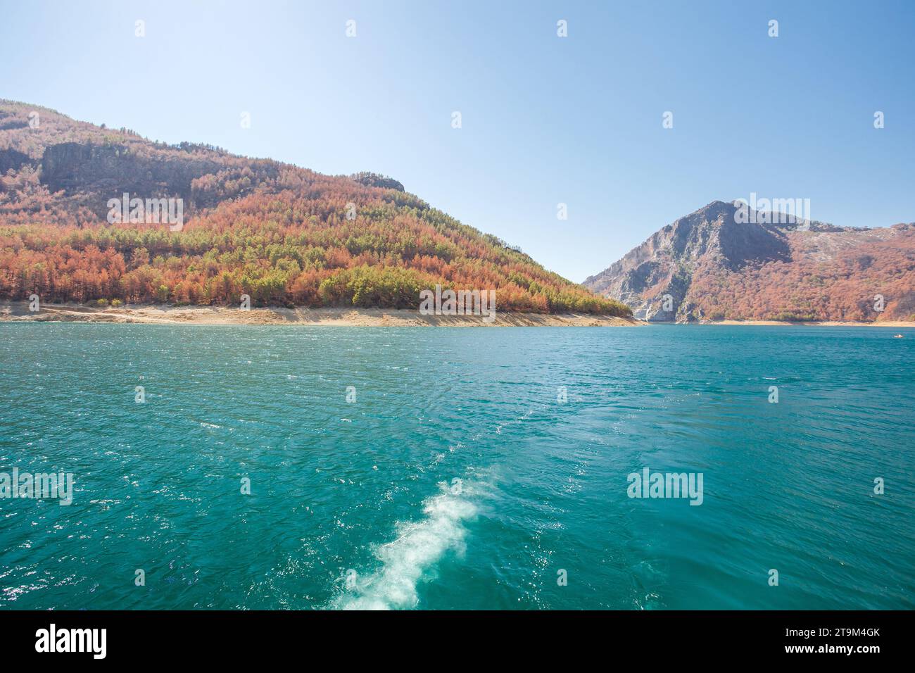 Surface of water in pond with blue water and mountains with rocks, wake ...