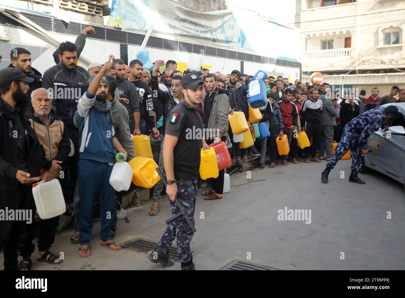 Rafah, Gaza. 25th Nov, 2023. Palestinians queue with jerry cans at a ...