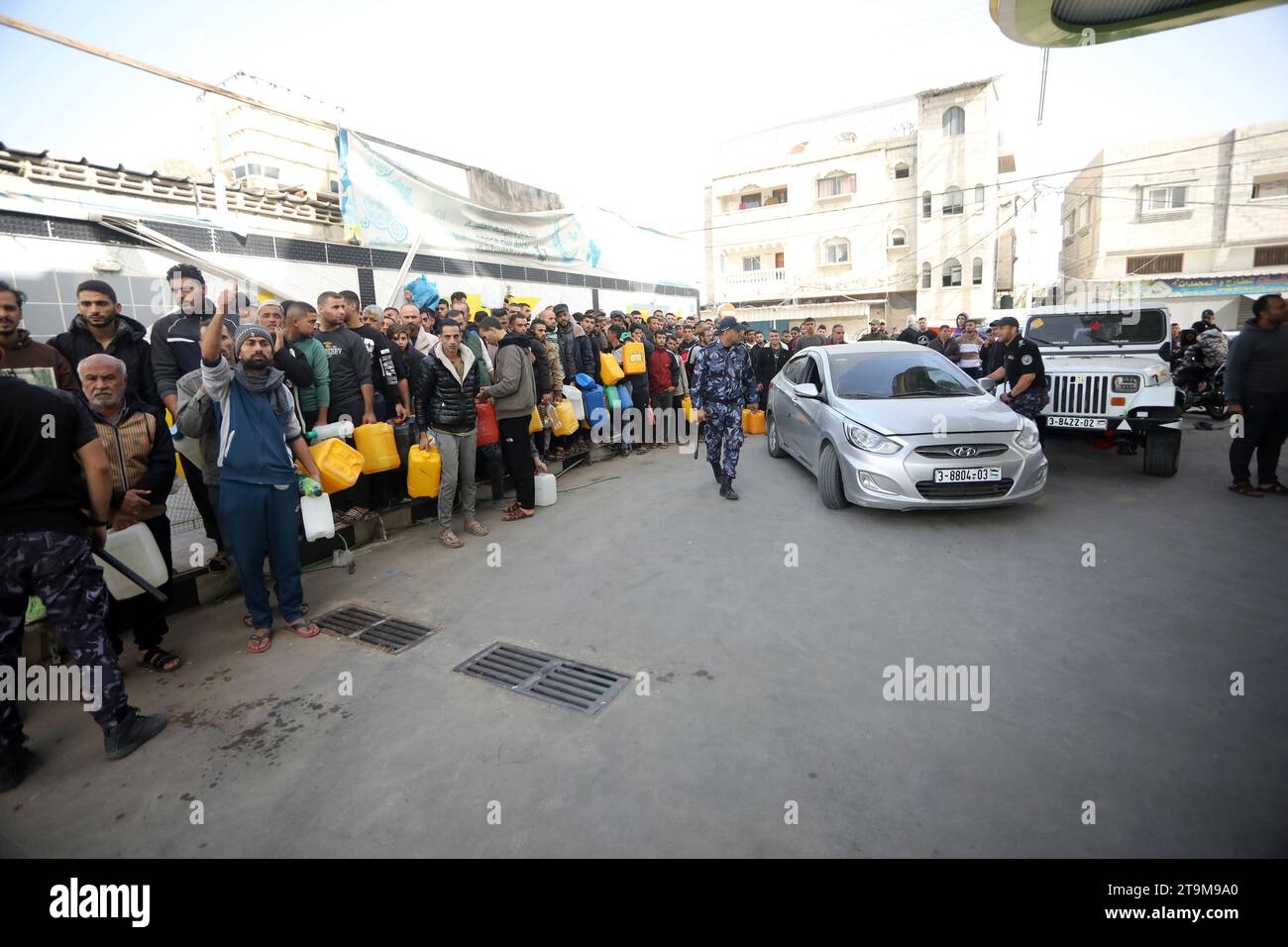Rafah, Gaza. 25th Nov, 2023. Palestinians queue with jerry cans at a ...