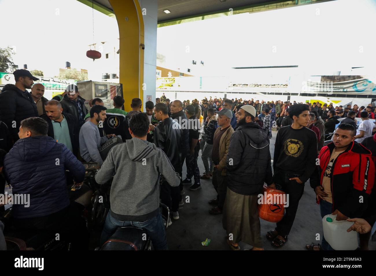 Rafah, Gaza. 26th Nov, 2023. Palestinians queue with jerry cans at a ...