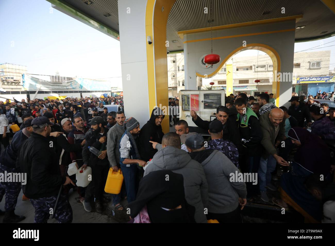 Rafah, Gaza. 25th Nov, 2023. Palestinians queue with jerry cans at a ...