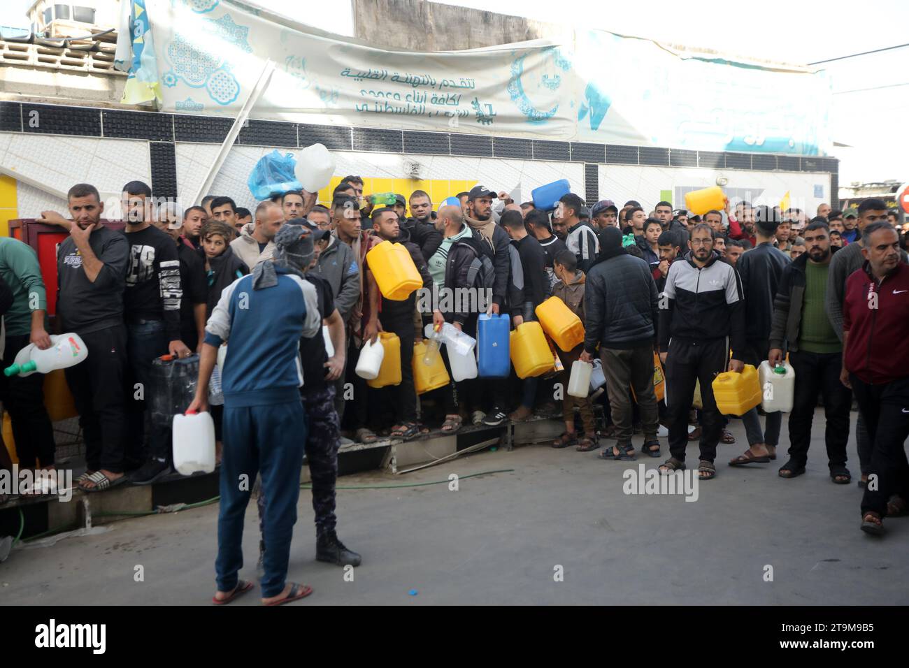 Rafah, Gaza. 25th Nov, 2023. Palestinians queue with jerry cans at a ...