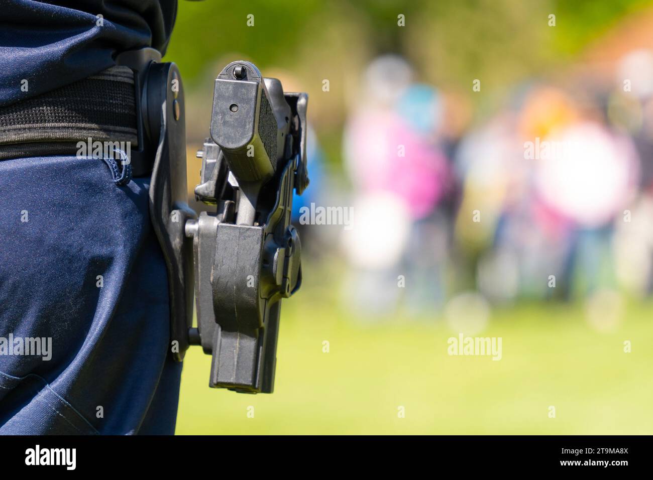 Police automatic pistol on the side of a police officer in blue uniform ...