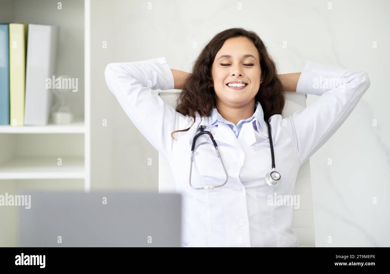 Relaxed woman doctor takes deep breath while working at clinic Stock ...
