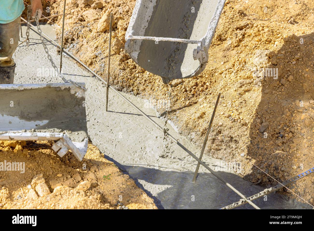 An individual laying cement pouring concrete in trenches for foundation ...