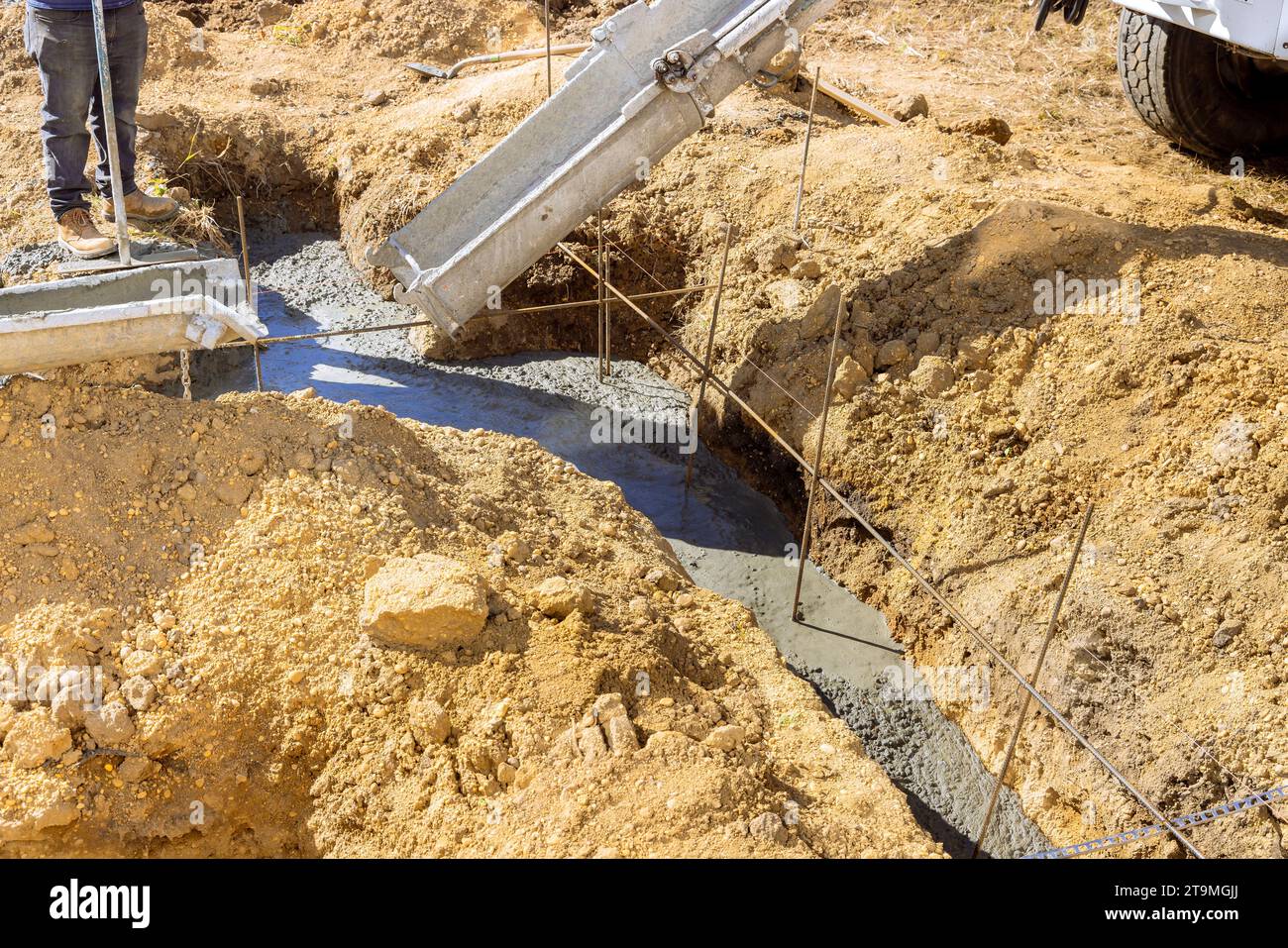 Laying cement concrete to trenches for foundation of house by ...