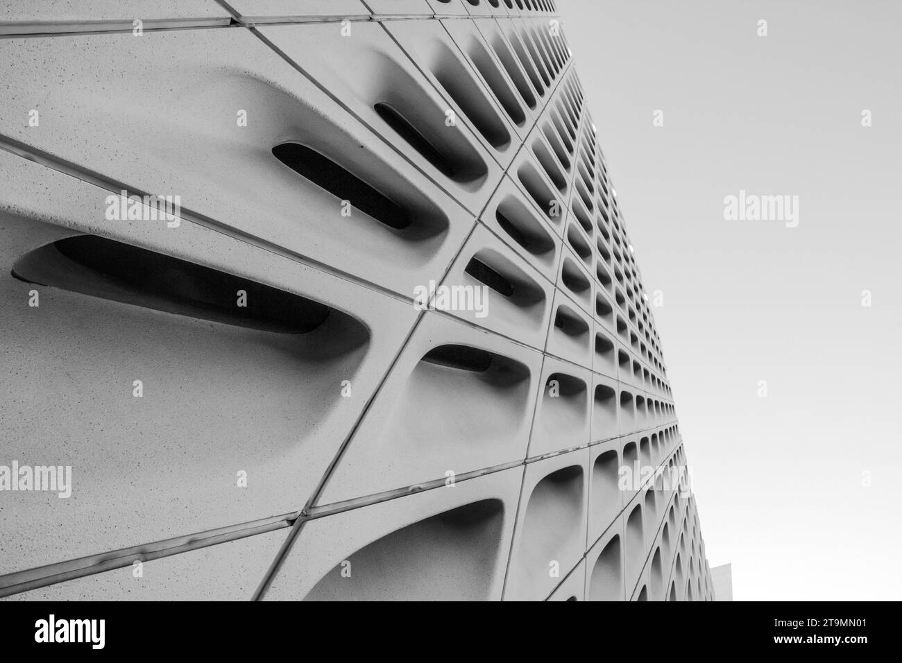 An architecturally modern building with perforated panels illuminated ...