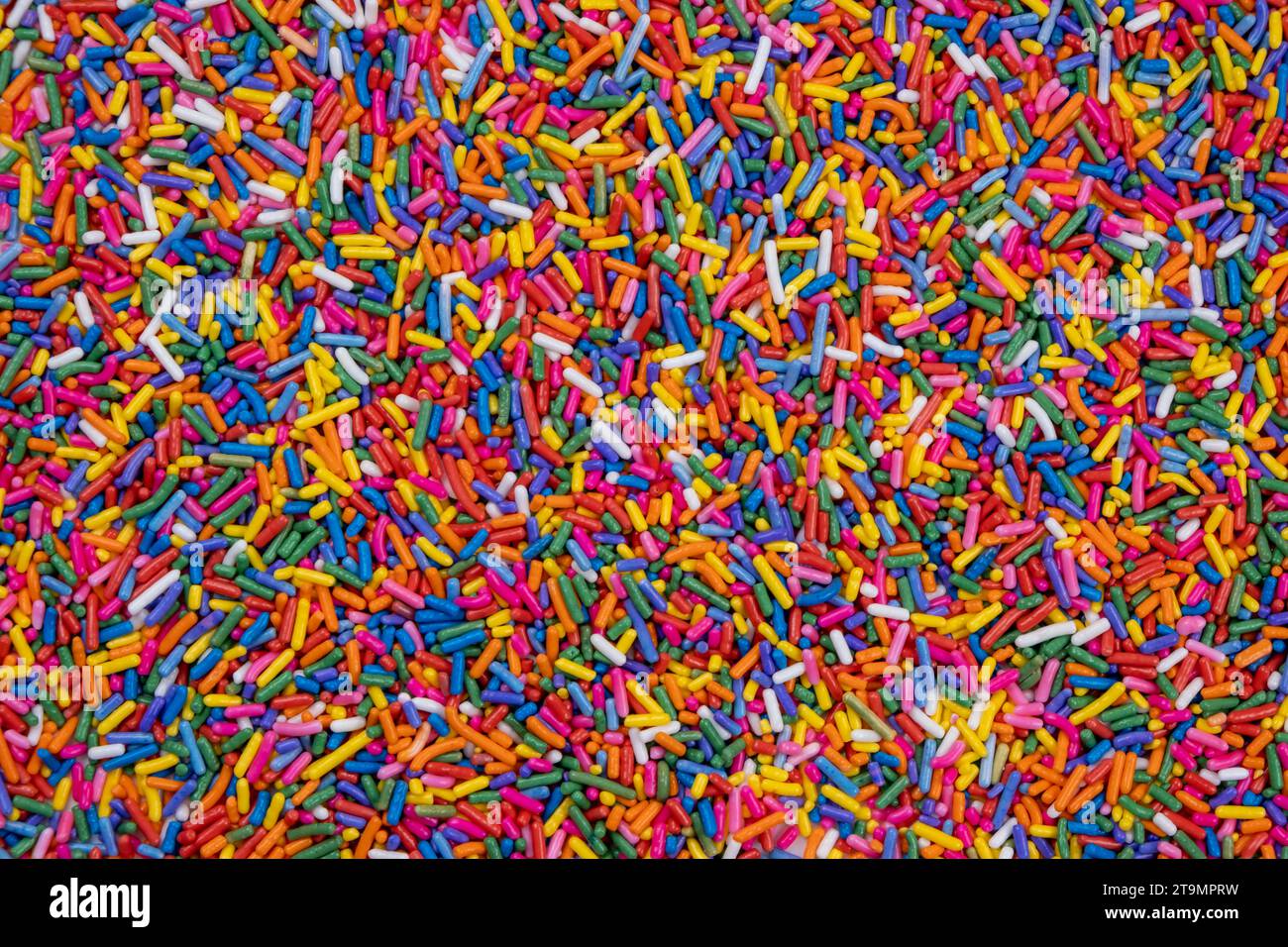 background of multi-colored sprinkles for sweets and multi-colored ...