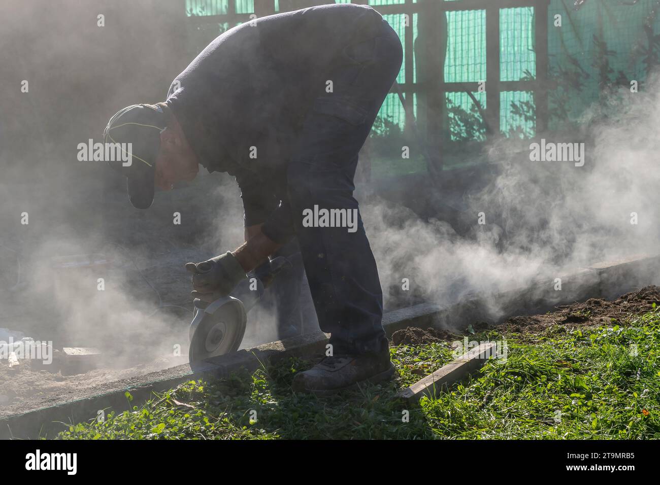 A man cuts a stone with an angle grinder Stock Photo - Alamy